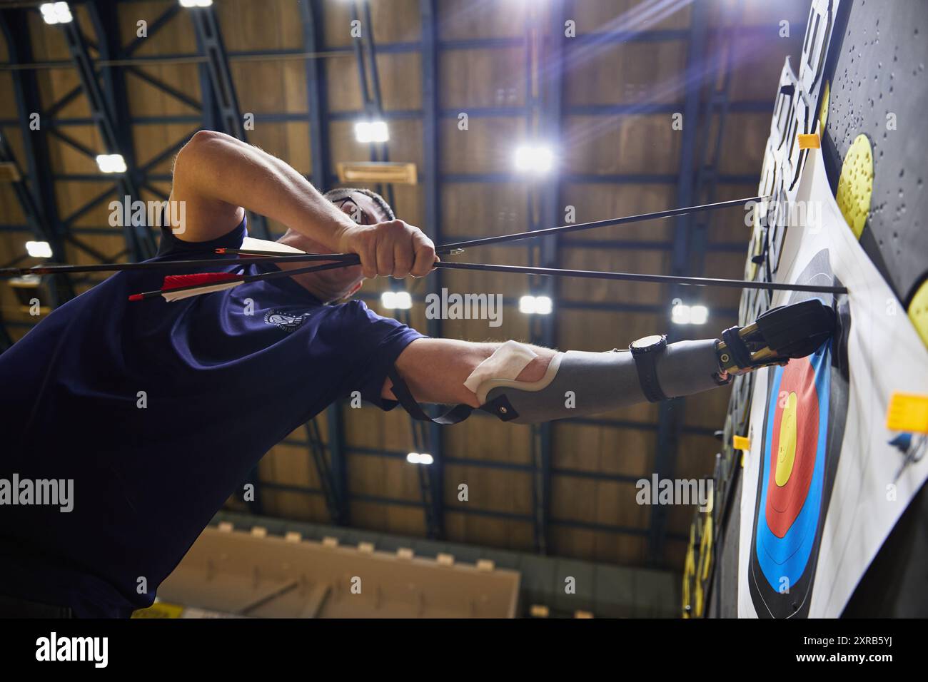 Archer with prosthetic arm takes arrow out of a target. Arst para ...