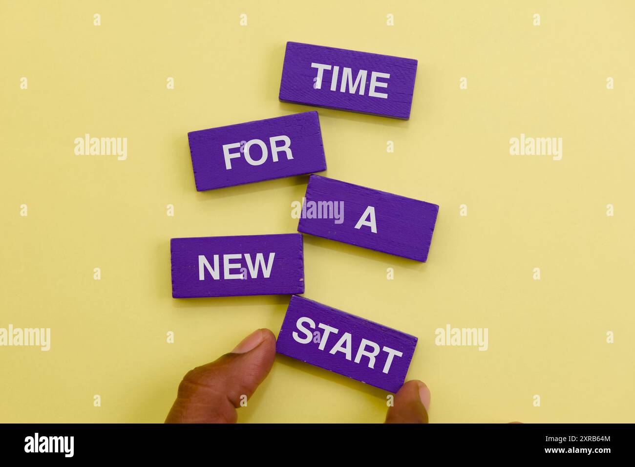 Purple blocks spell out "Time for a New Start" on a yellow background ...