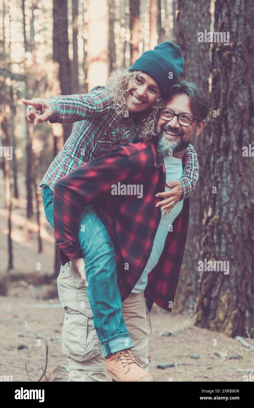 Playful happy handsome caucasian couple having piggyback while walking ...