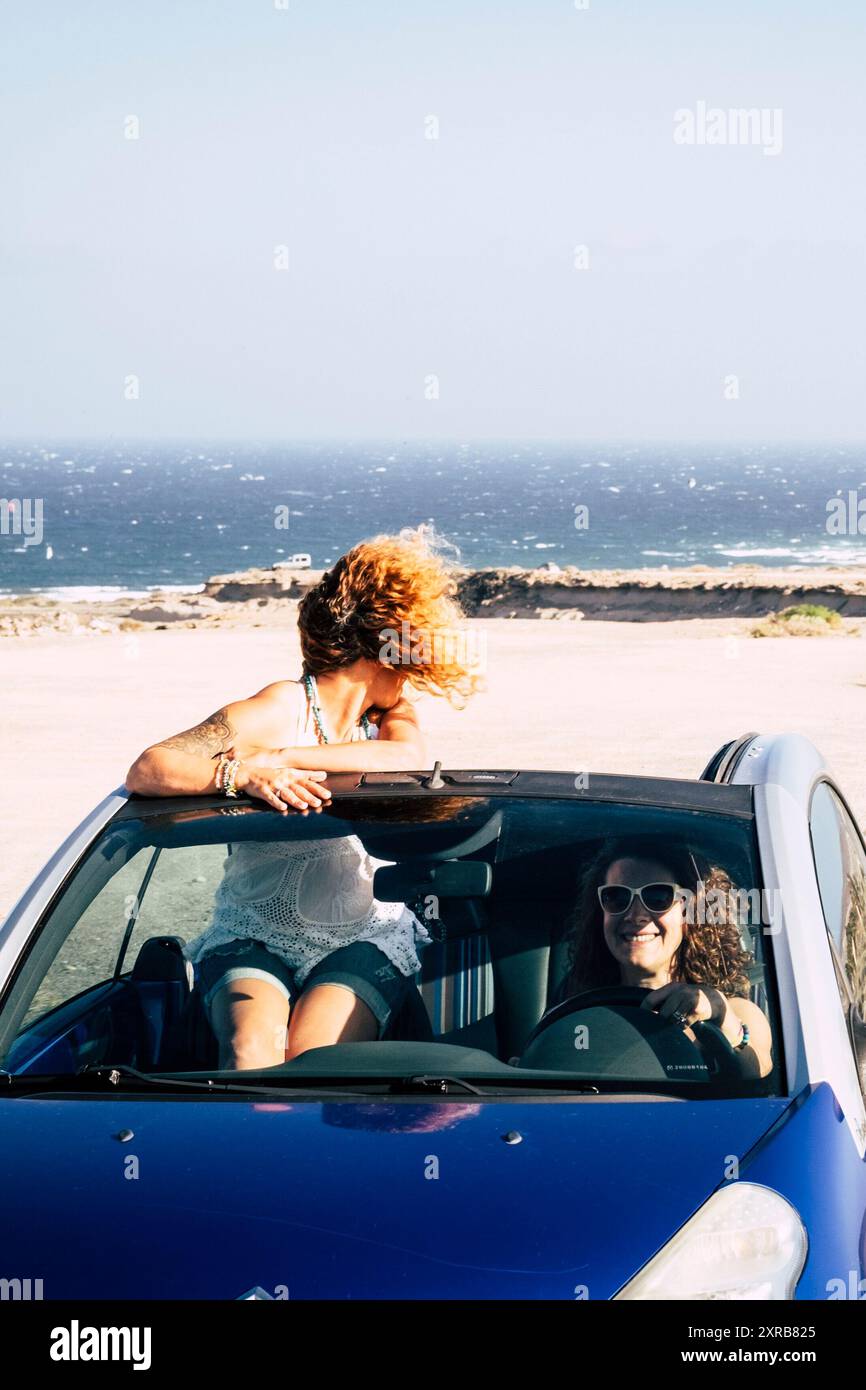 Car travel friends transportation two happy woman ejoy convertible auto ...