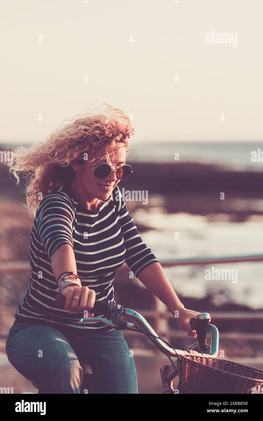 Young woman enjoy bike ride and smile in outdoor active leisure ...