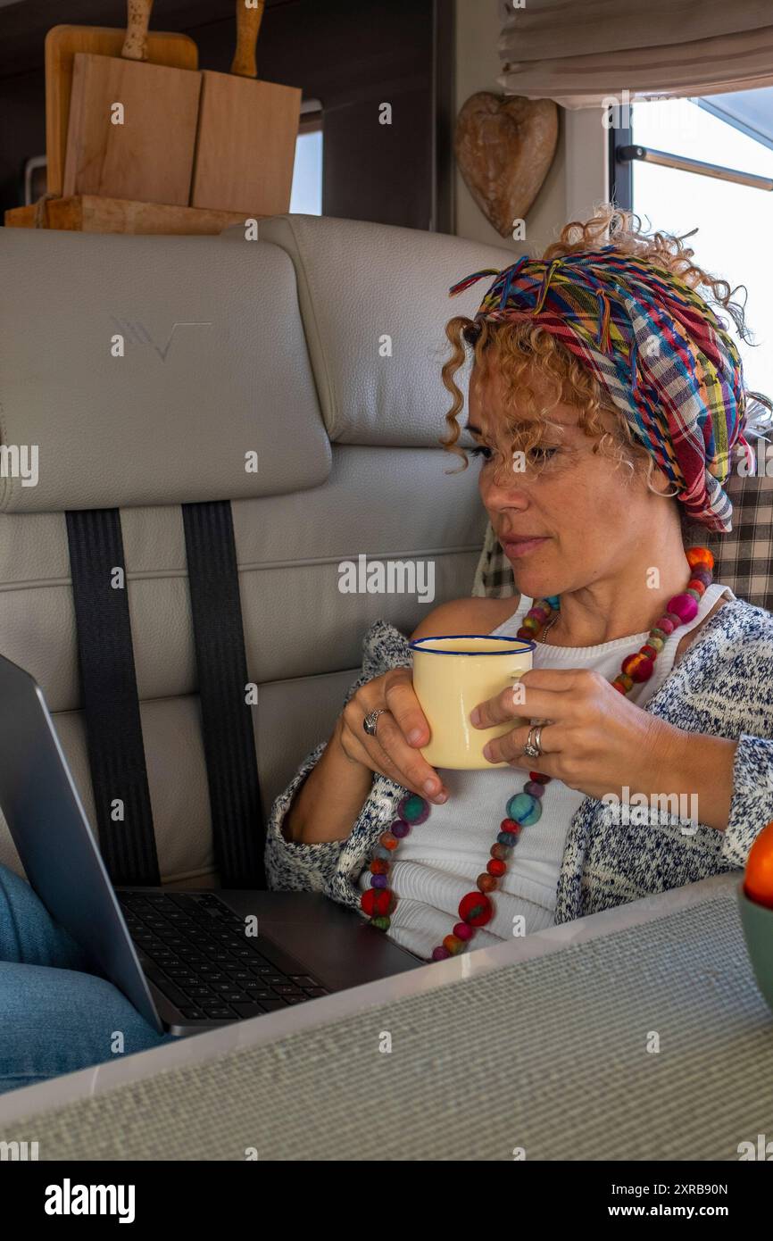 One independent woman laying and working inside a camper van with ...
