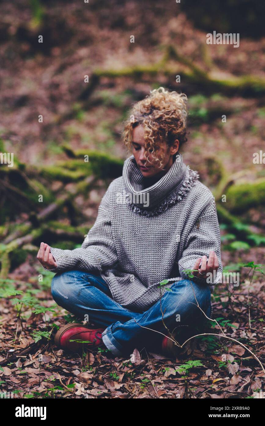 Woman sit down outdoor in the middle of nature and forest woods ...