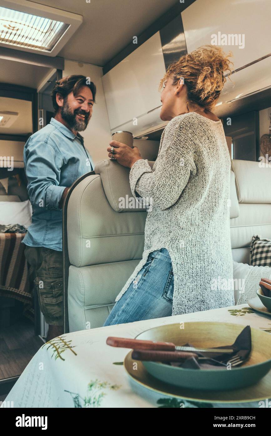 Happy adult couple enjoy vacation on camper van and prepare lunch ...