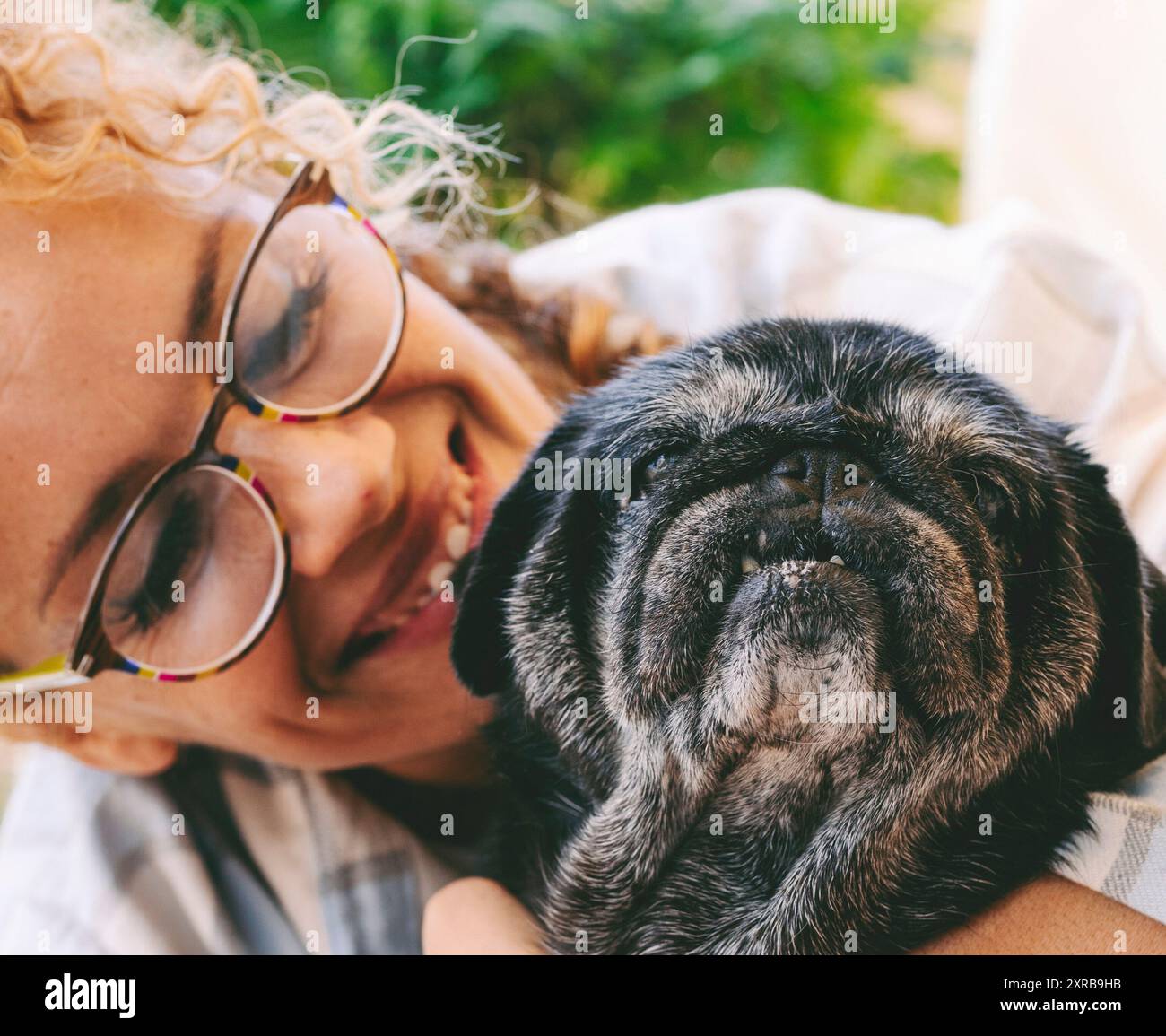 Cheerful woman hugging black old dog with love and freindship. Animal ...