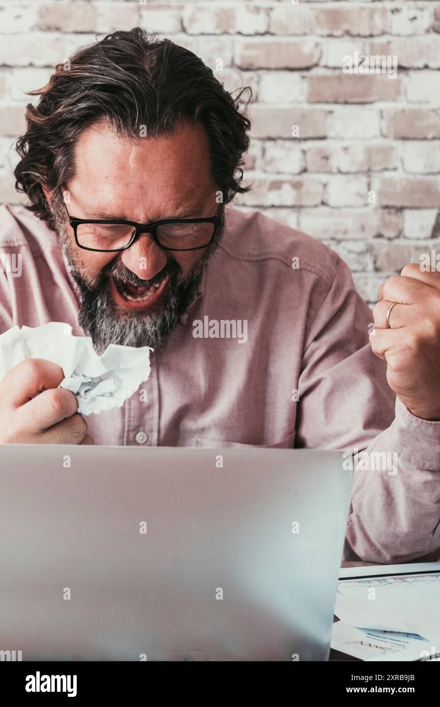 Angry man in bad expression looking a computer display with bad ...