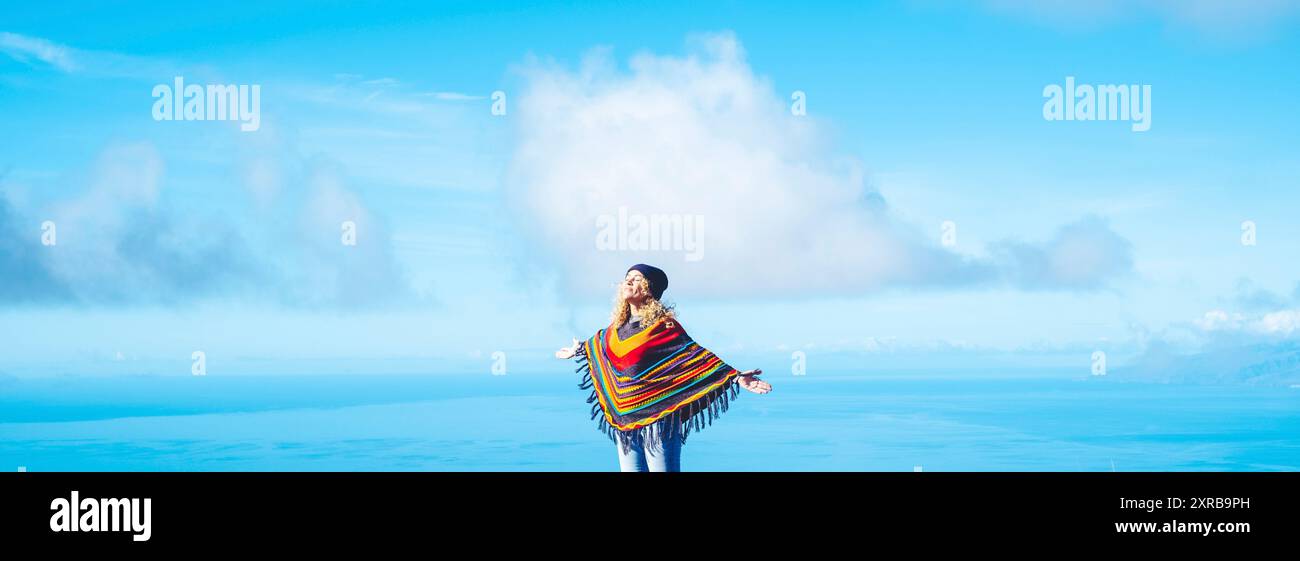 Woman relaxing with open arms in blue winter sky. People's freedom ...