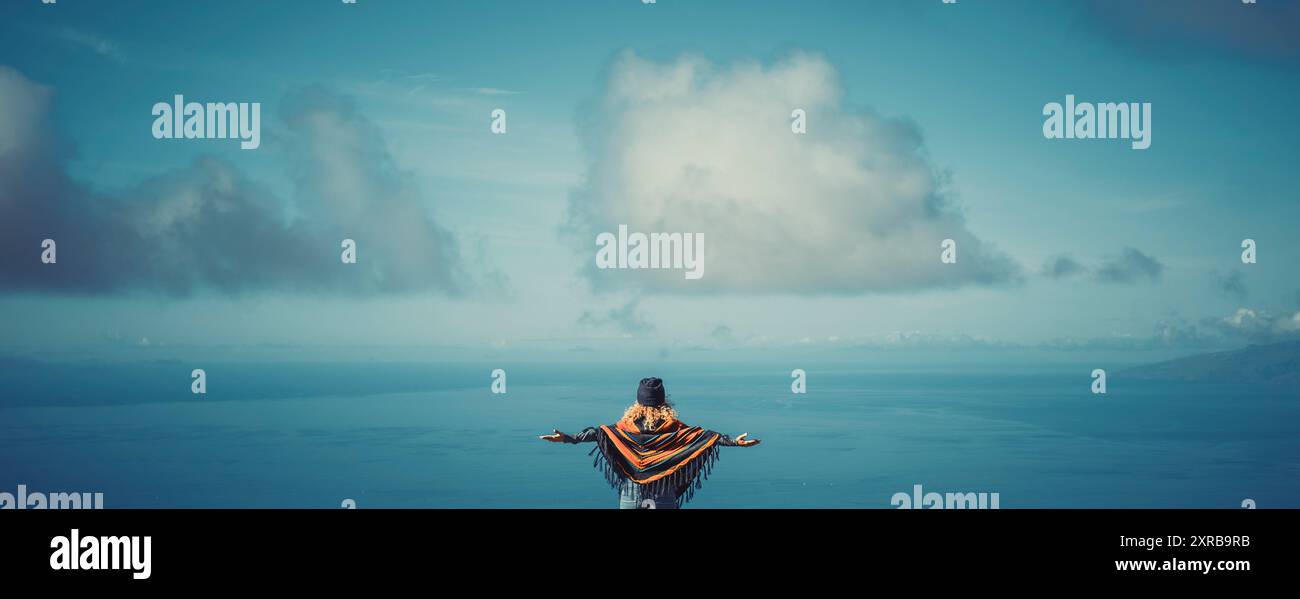 Woman relaxing with open arms in blue winter sky. People's freedom ...