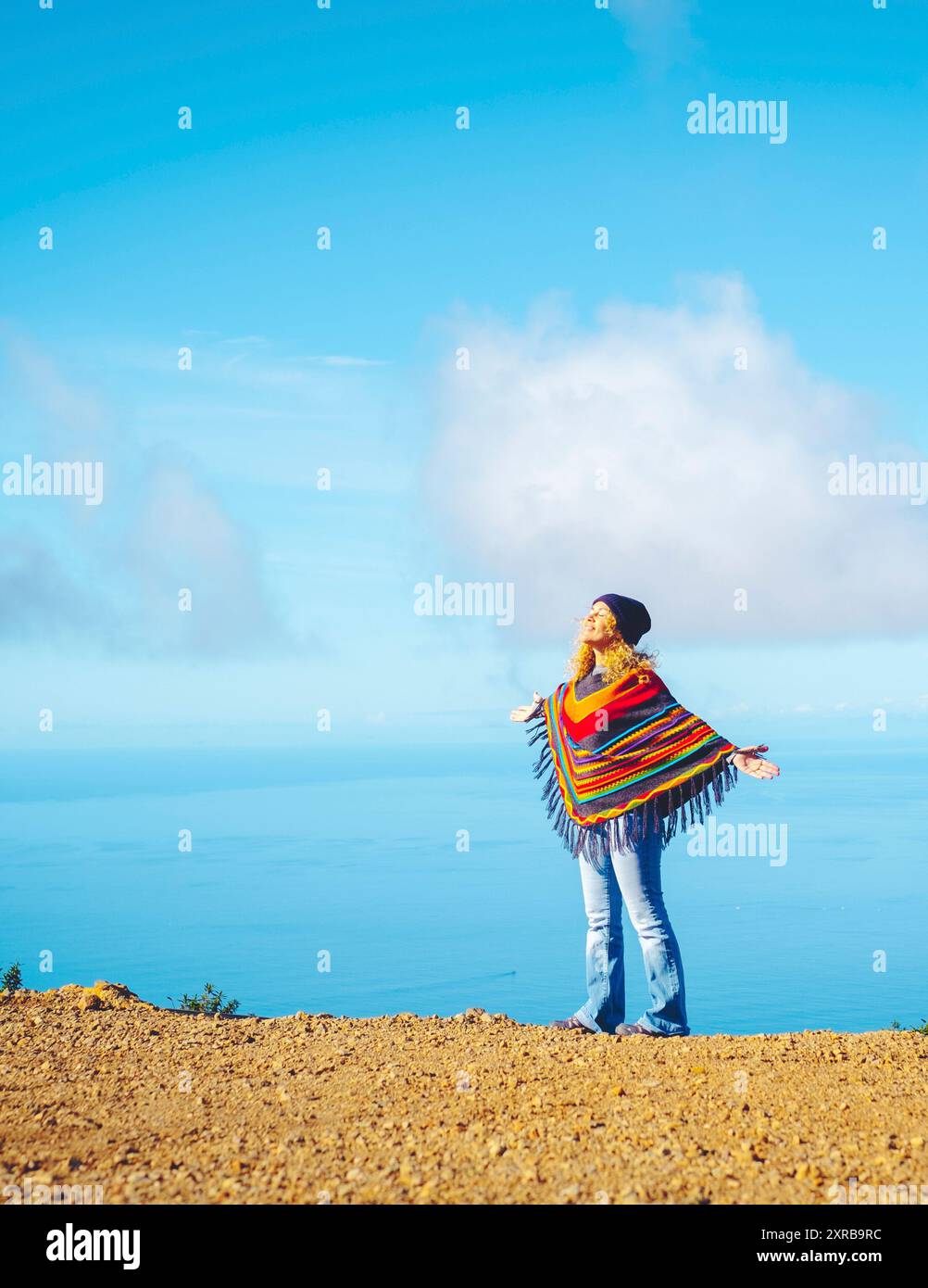 Woman relaxing with open arms in blue winter sky. People's freedom ...