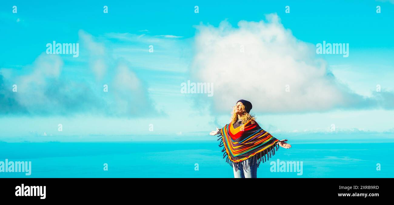 Woman relaxing with open arms in blue winter sky. People's freedom ...