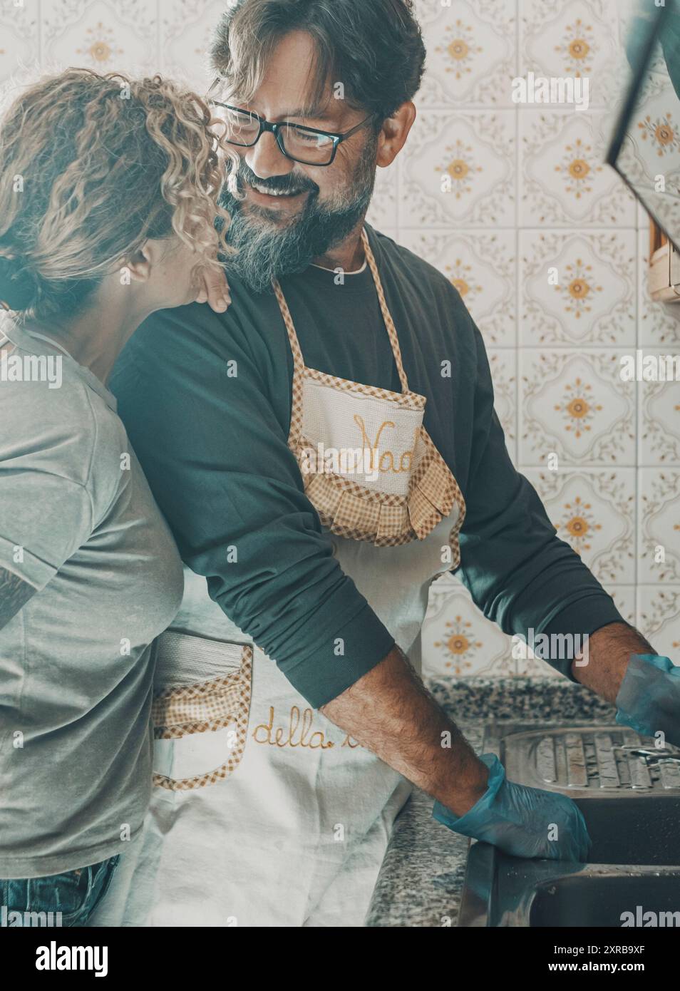 Couple at home in domestic activity together washing dishes in the ...