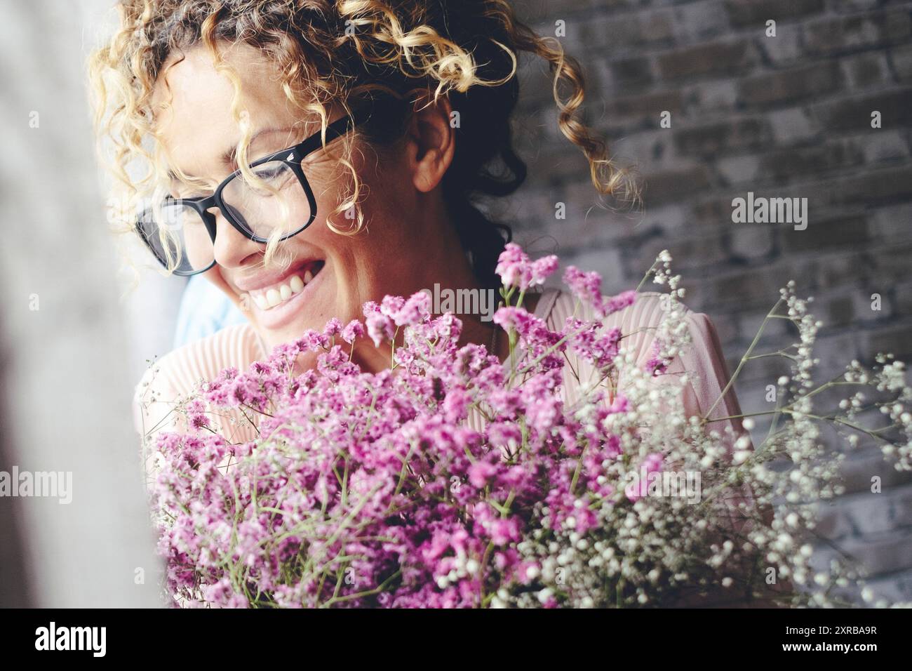 One excited overjoyed young woman at home with big flowers bouquet ...