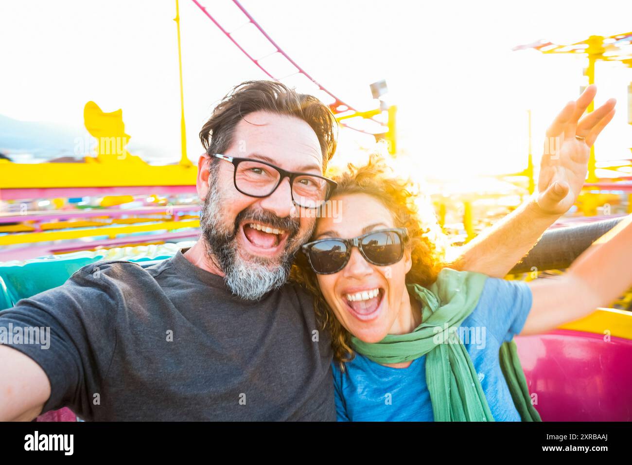 Adult couple have fun together on a roller coaster in amusement park ...