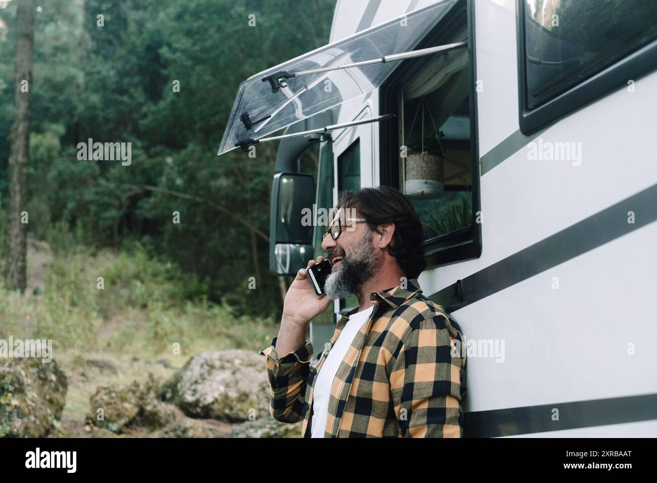 One man outside a motorhome do a phone call with a smile. People and ...