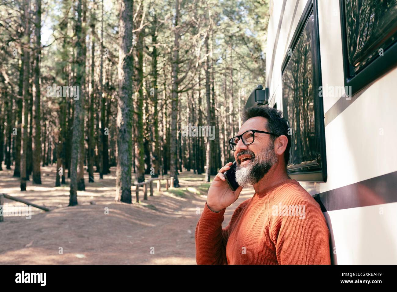 Travelers man standing outside a modern motorhome camper van enjoying ...
