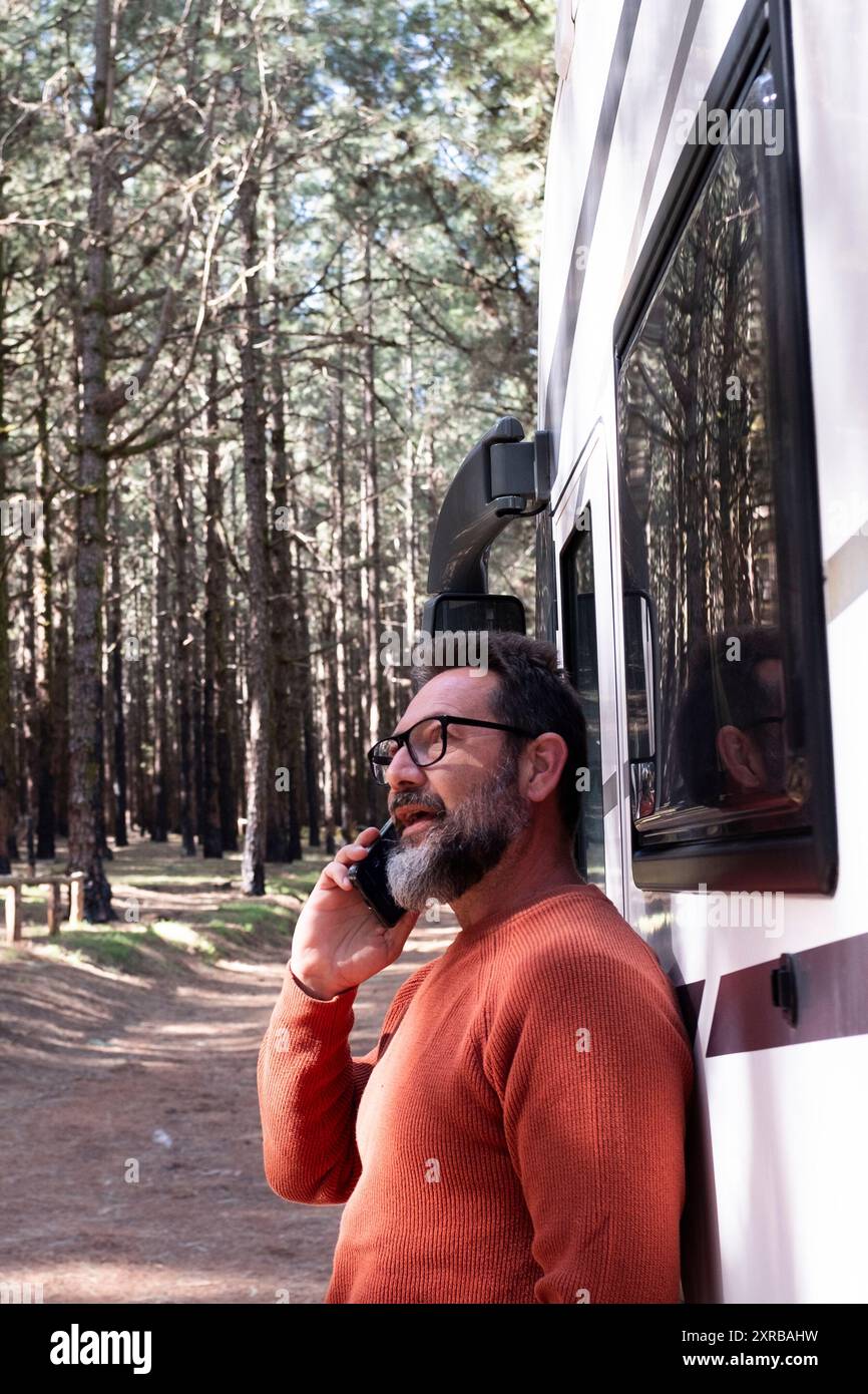 Travelers man standing outside a modern motorhome camper van enjoying ...