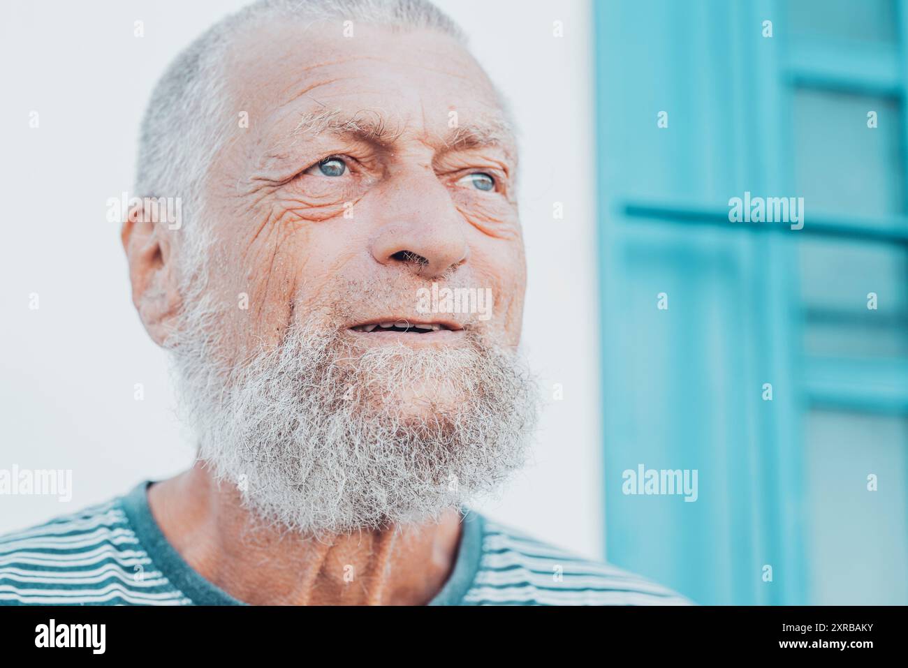 Serious expression of charming man with blue eyes. 75 year old elderly ...