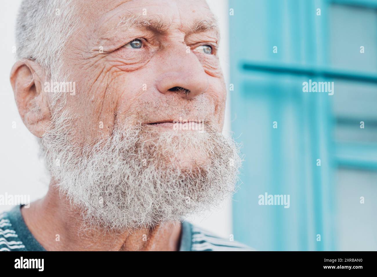 Serious expression of charming man with blue eyes. 75 year old elderly ...