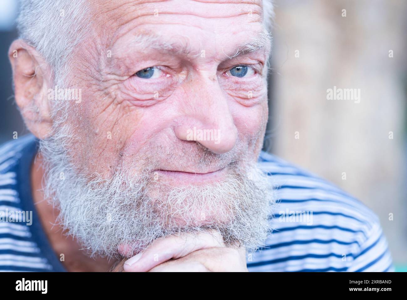 Serious expression of man with blue eyes. 75 year old senior man with ...