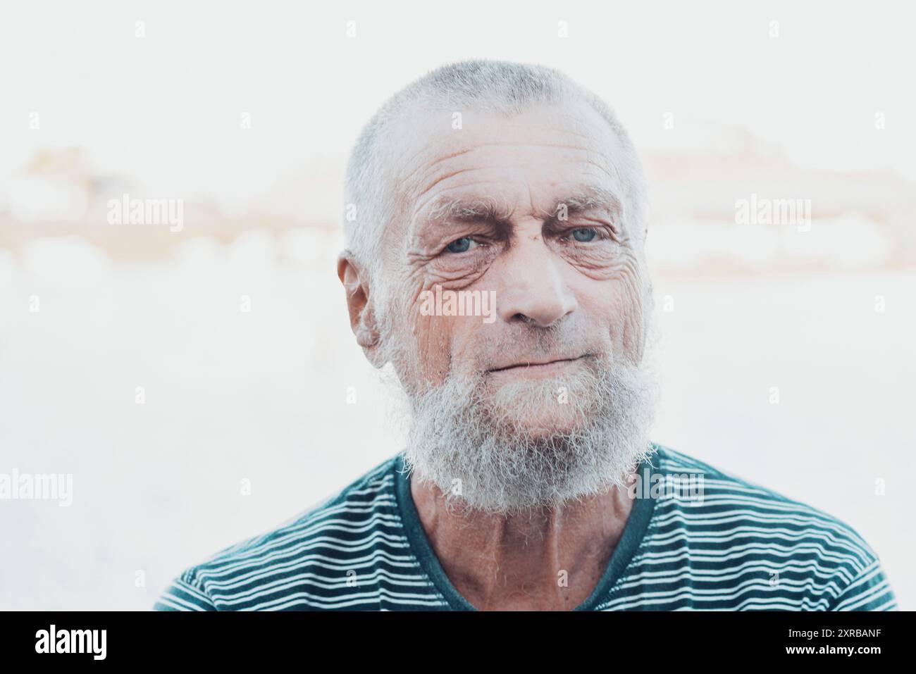 Serious expression of man with blue eyes. 75 year old senior man with ...