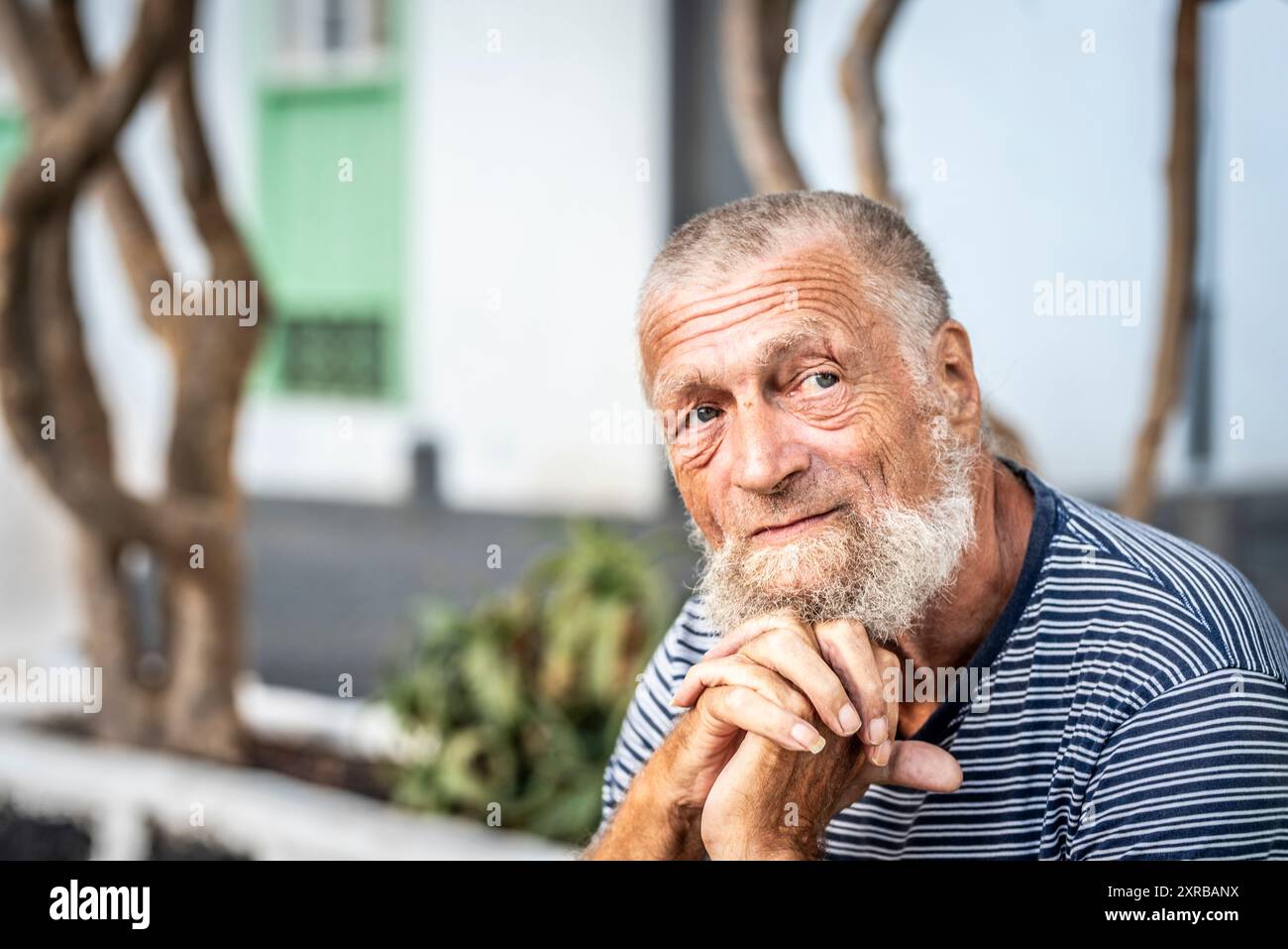Serious expression of charming man with blue eyes. 75 year old elderly ...