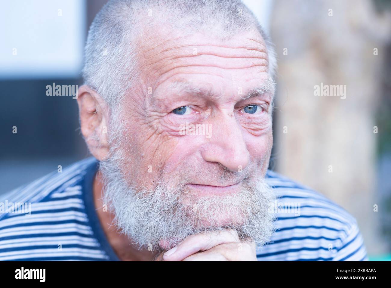 Serious expression of man with blue eyes. 75 year old senior man with ...