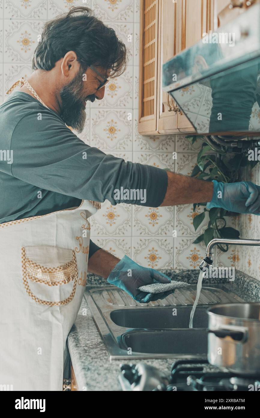 Husband one man washing dishes at home alone smiling and enjoying ...