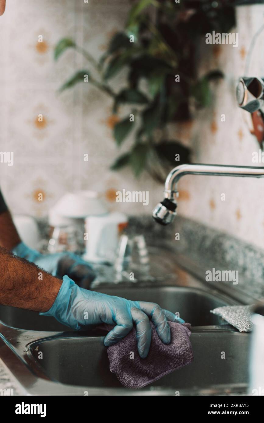 Close up of man at home cleaning the kitchen after cooking and washing ...