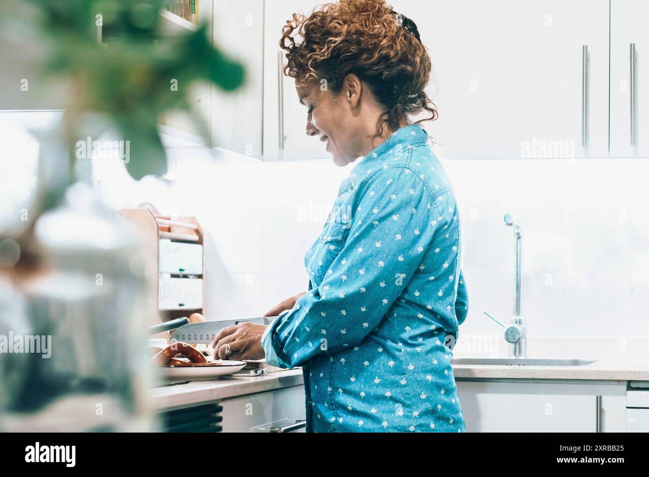 Indoor cooking leisure activity with happy young mature woman preparing ...