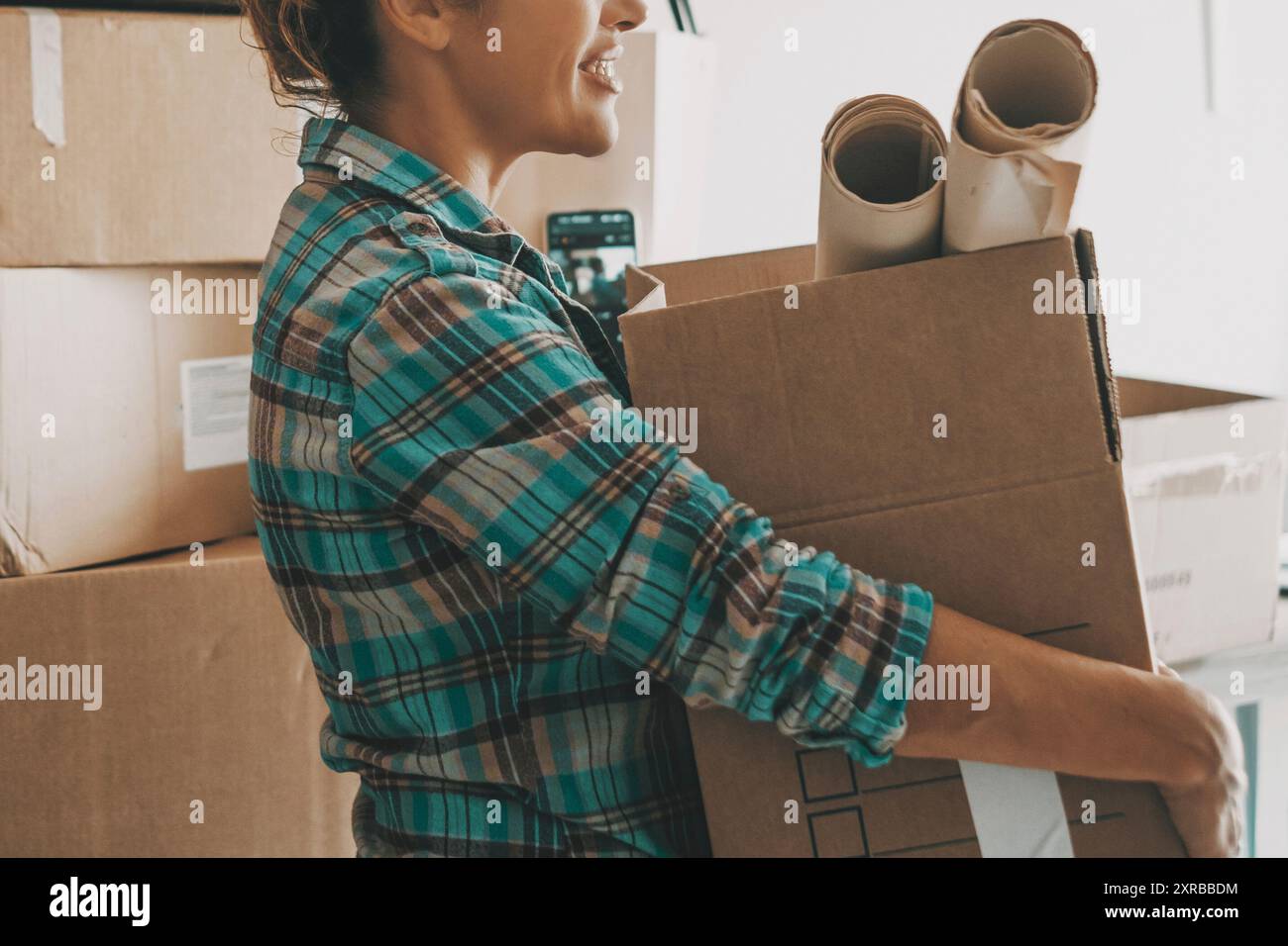 Happy adult woman relocating house lifting cardboard box with life ...