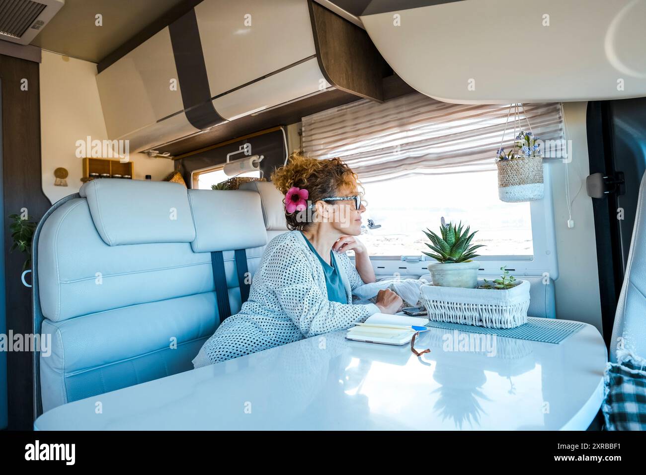One woman relaxes inside a camper van motorhome rv vehicle. lady loves ...