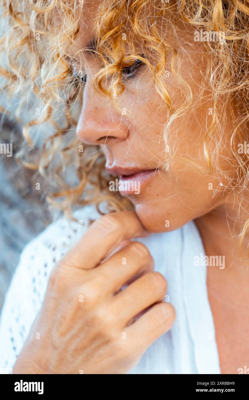 Sad and lonely adult woman touching her chin and looking down with ...