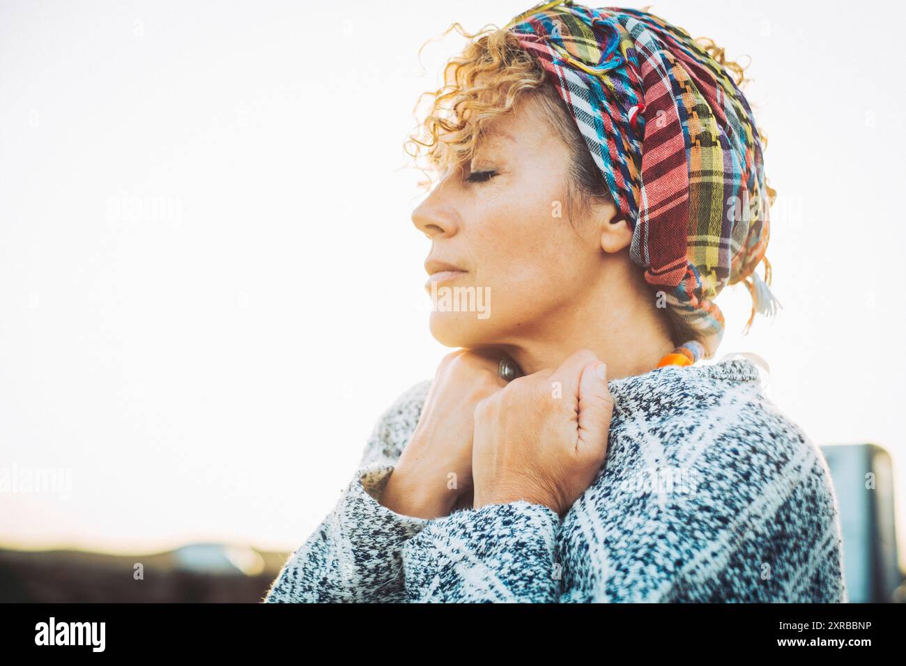Portrait of beautiful curly blonde woman with closed eyes. Outdoor ...