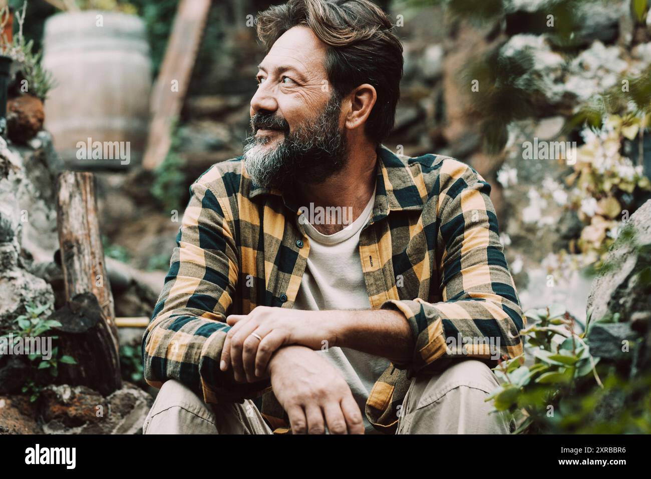 One happy and serene adult man sitting outdoor in the green nature ...