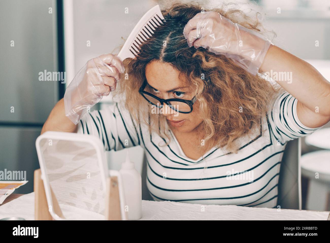 Young mature lady at home having care of her long hair looking for ...
