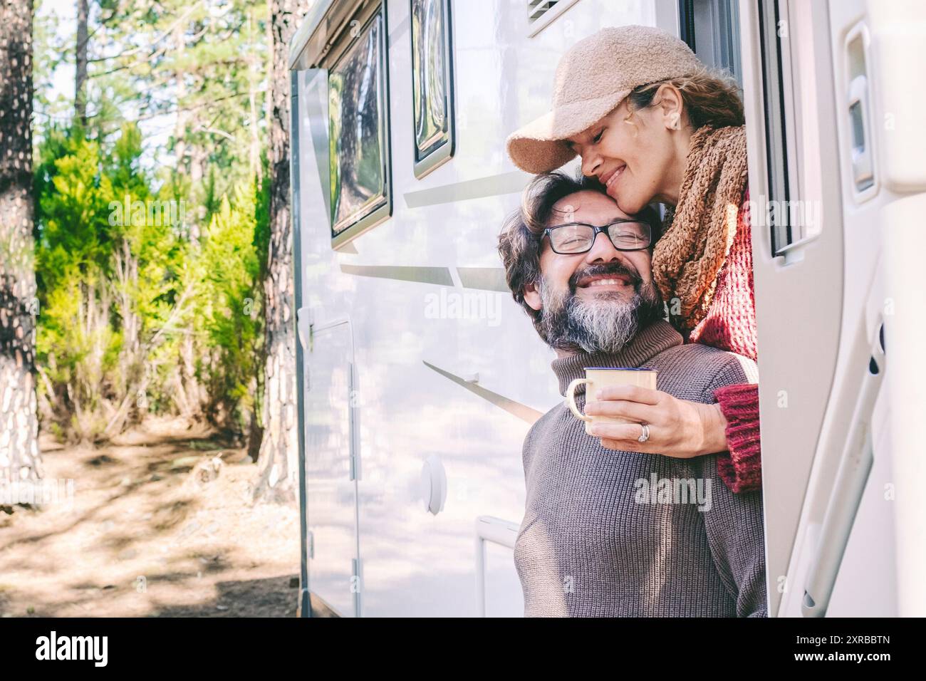 Happy people on travel lifestyle sitting on the door of a camper van ...