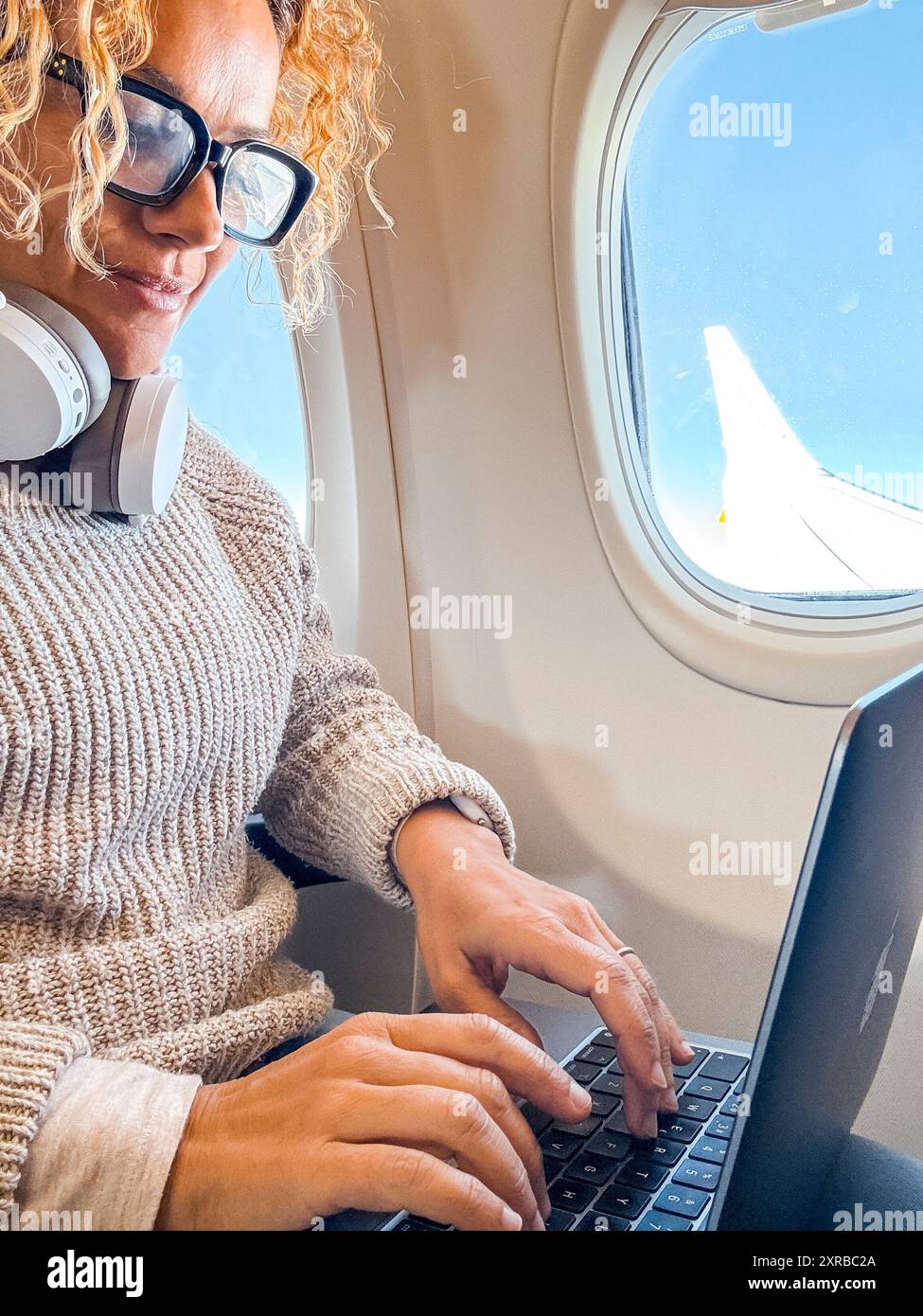 Travel and technology. I fly for work. Middle aged business woman ...