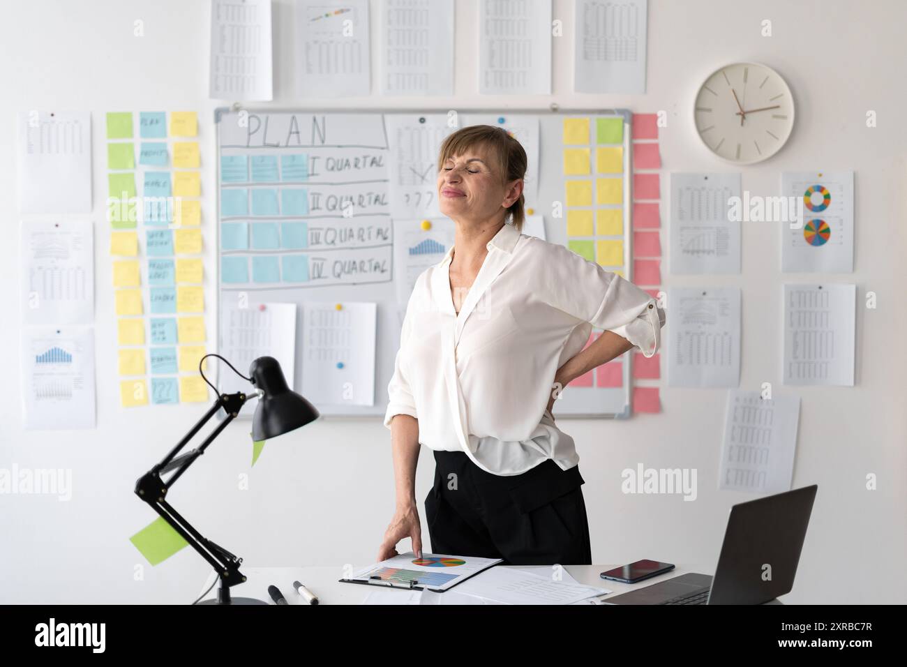 Elderly woman having back pain after work long time using laptop ...