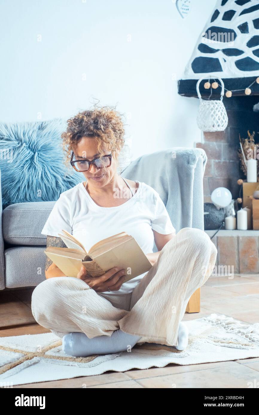 Stay home pastimes. Boomer mature woman sitting on the floor with open ...