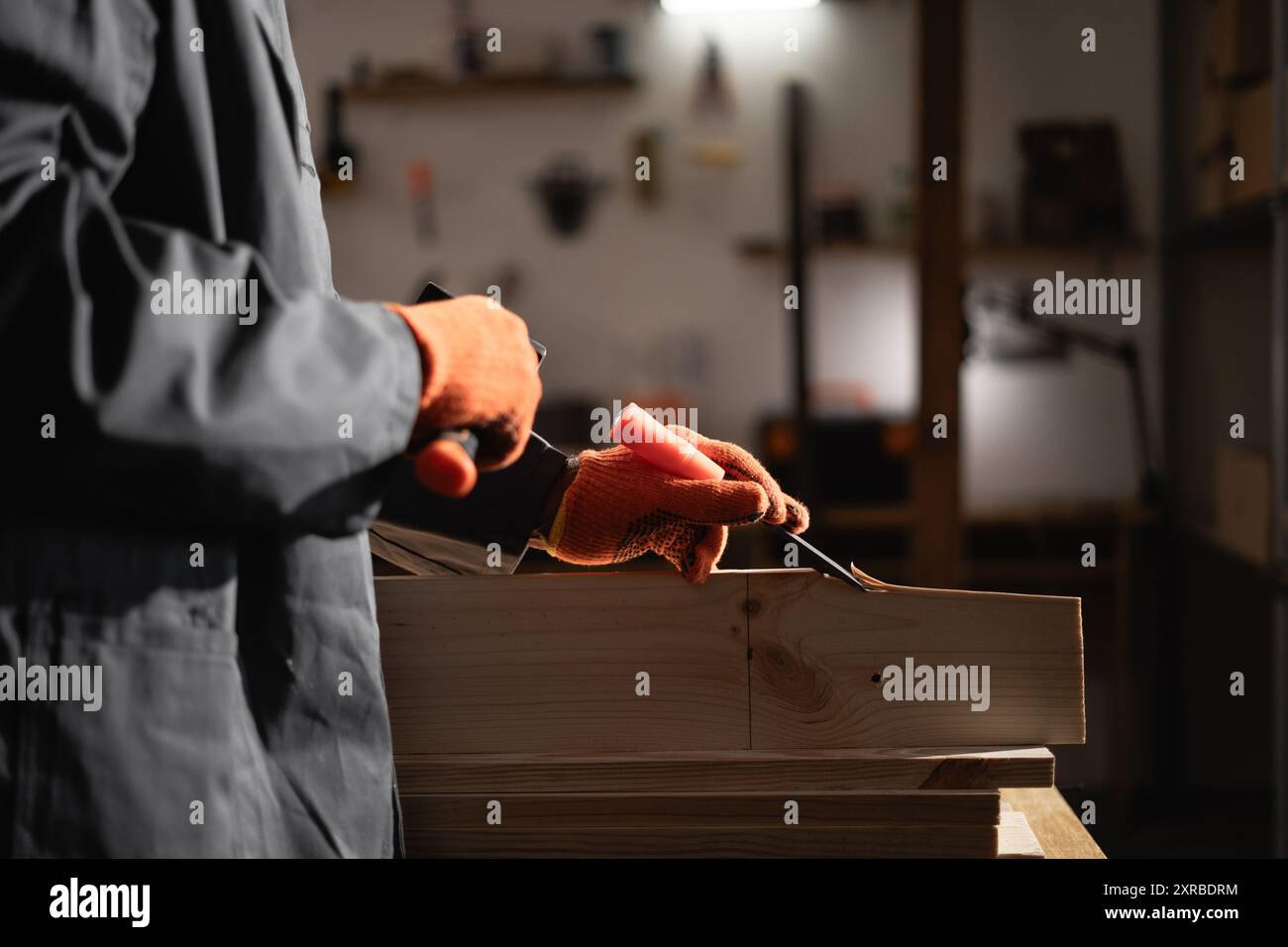 man carves a tree with chisel and hammer. Carpenter works in studio ...