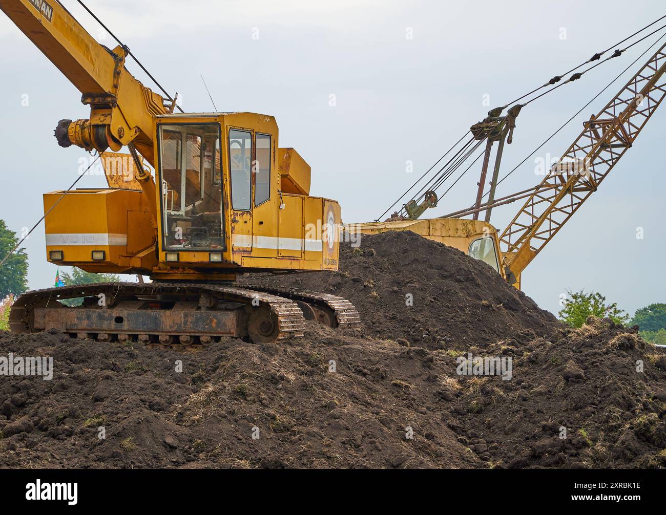 Two excavators clearing soil Stock Photo - Alamy