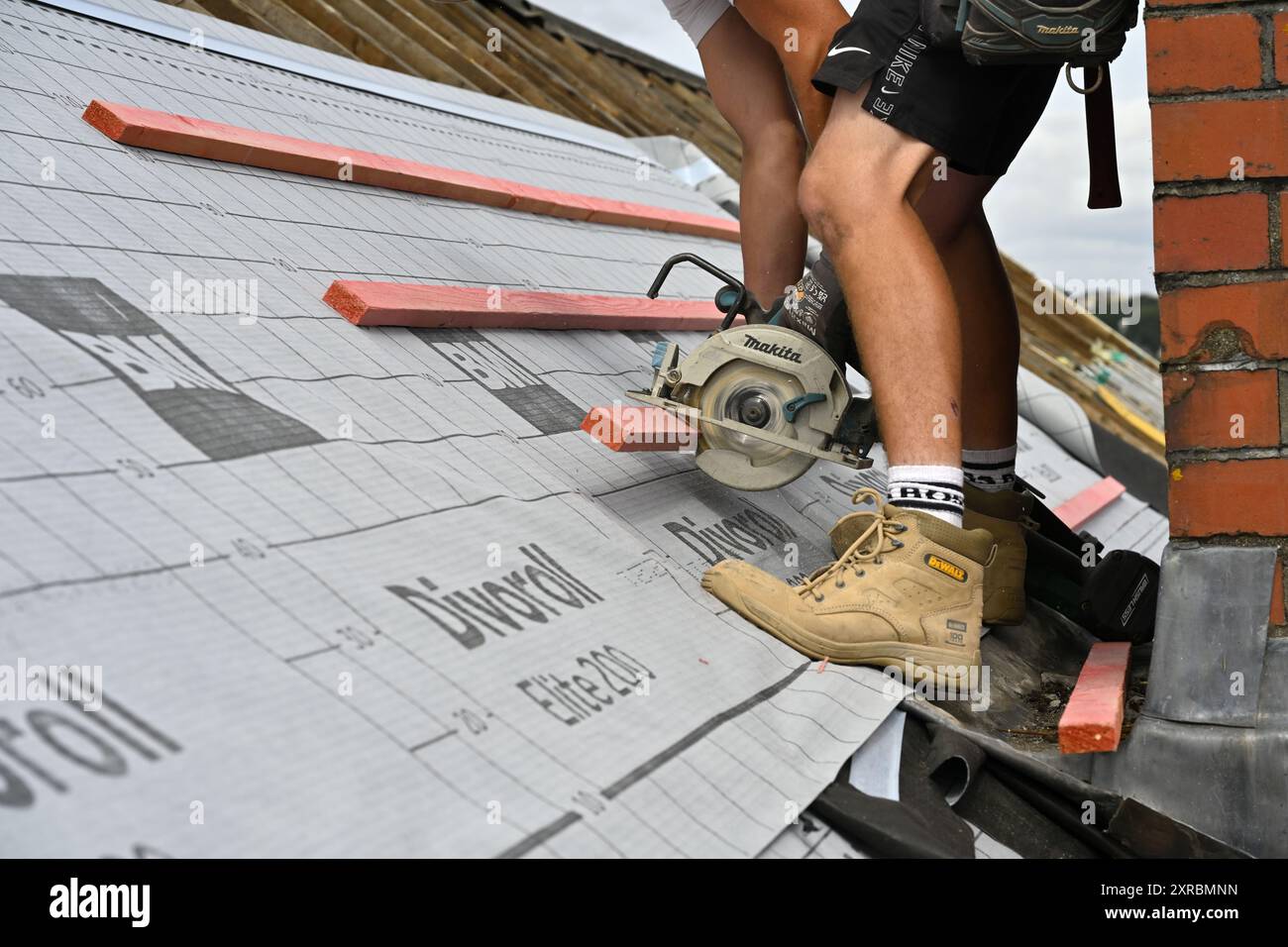 Roofing work, roofer using circular saw to cut new wooden battens on ...