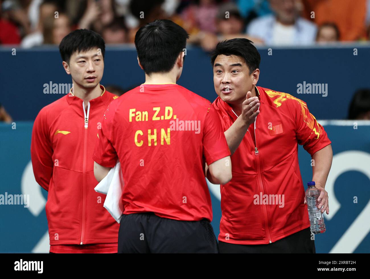 Paris, France. 9th Aug, 2024. Coach Wang Hao (R) of China gives instructions to Fan Zhendong ...