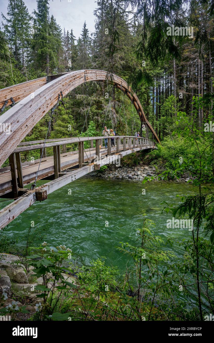 Hikers crossing the bridge over the Middle Fork Snoqualmie River in the ...
