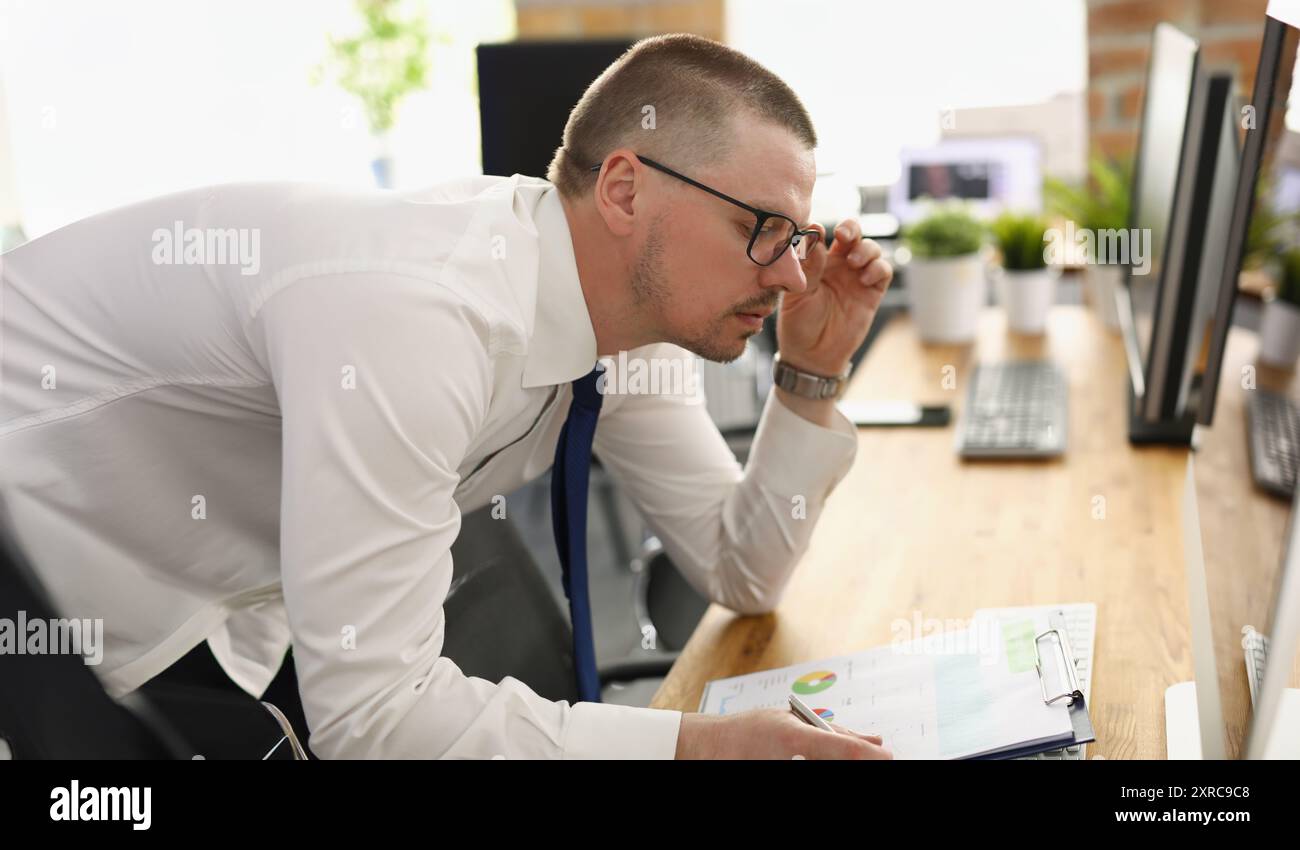A man in the office is editing a report with a diagram Stock Photo - Alamy