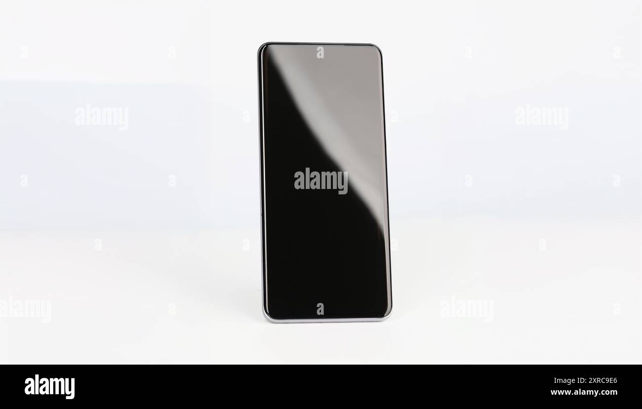 Black smartphone stands upright on a white background Stock Photo - Alamy