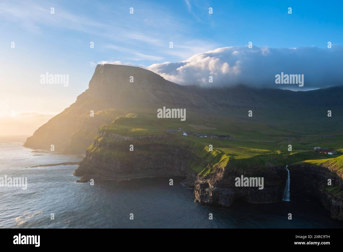 Aerial view of the Mulafossur waterfall with the small village of ...