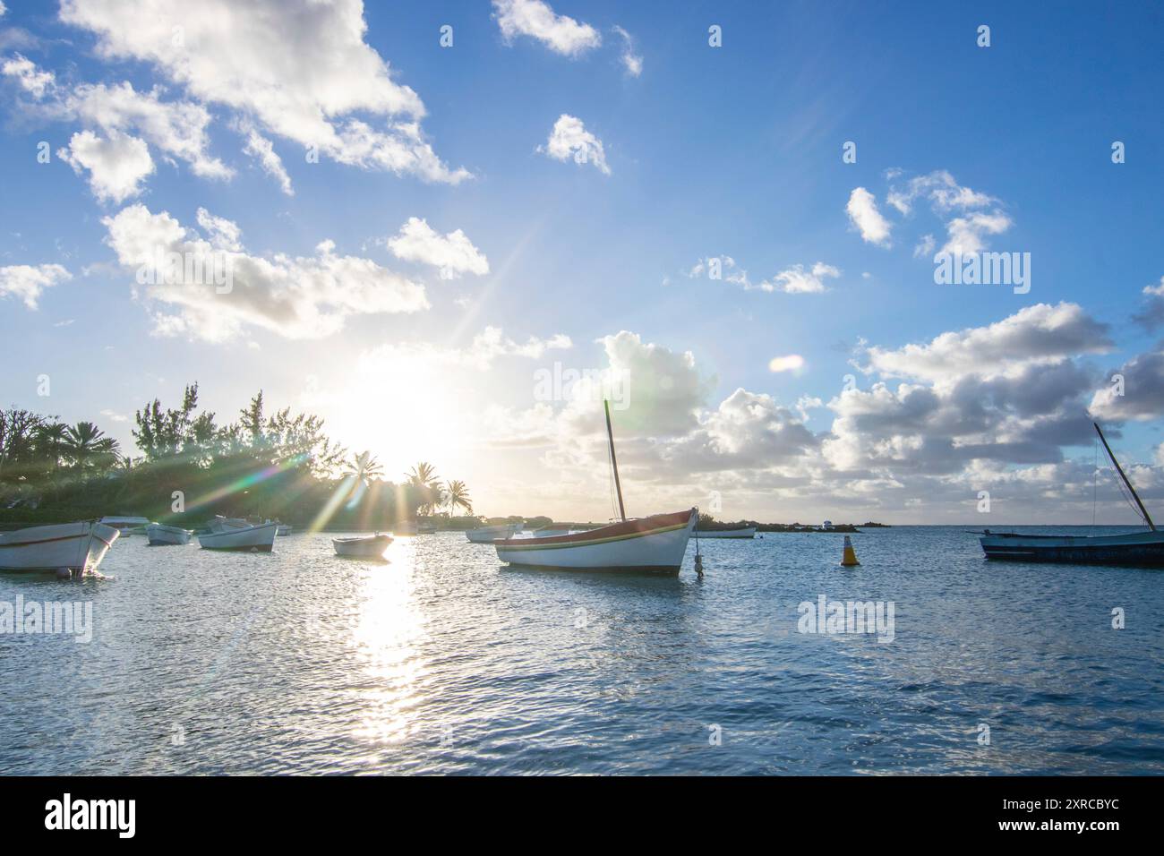 Landscape with a view over a small harbor with fishing boats at sunset ...