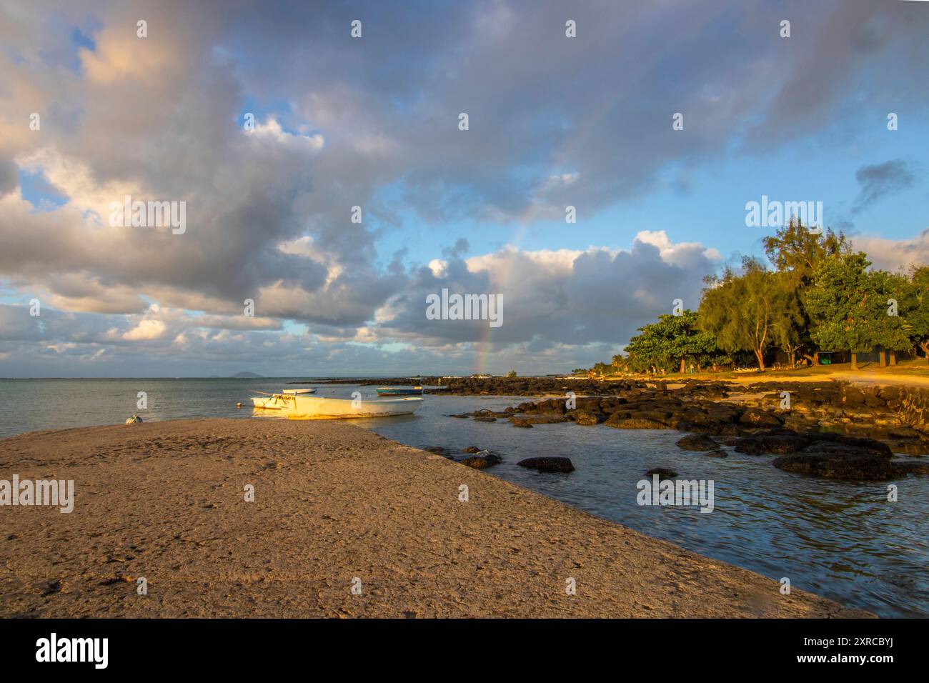 Landscape with a view over a small harbor with fishing boats at sunset ...