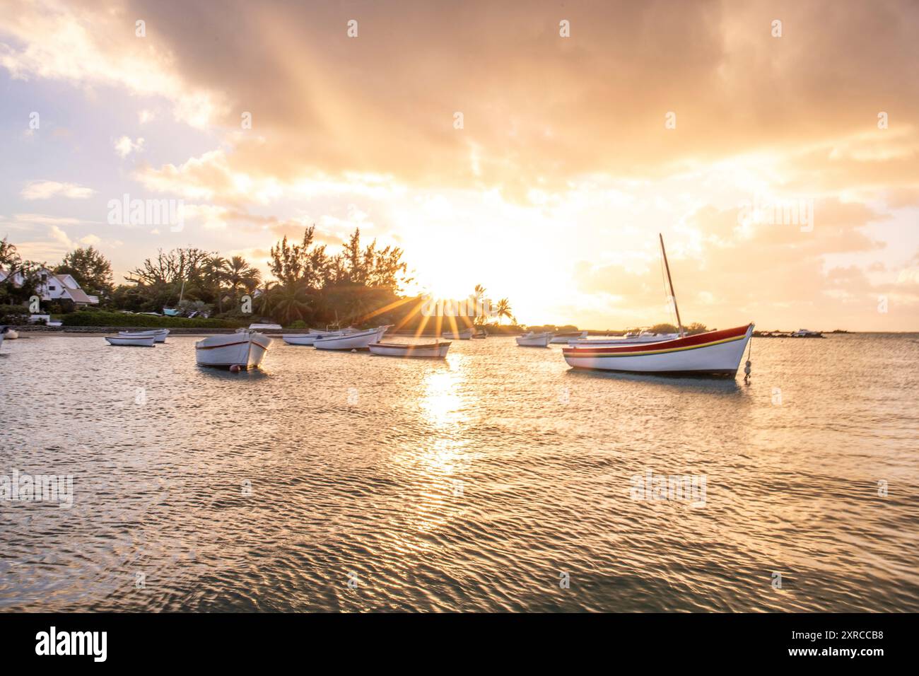 Landscape with a view over a small harbor with fishing boats at sunset ...